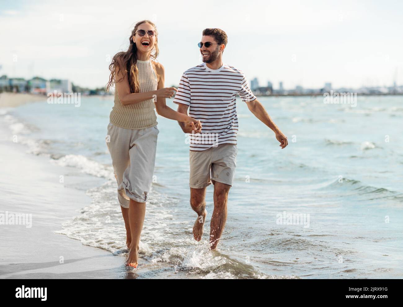 happy couple running along summer beach Stock Photo - Alamy