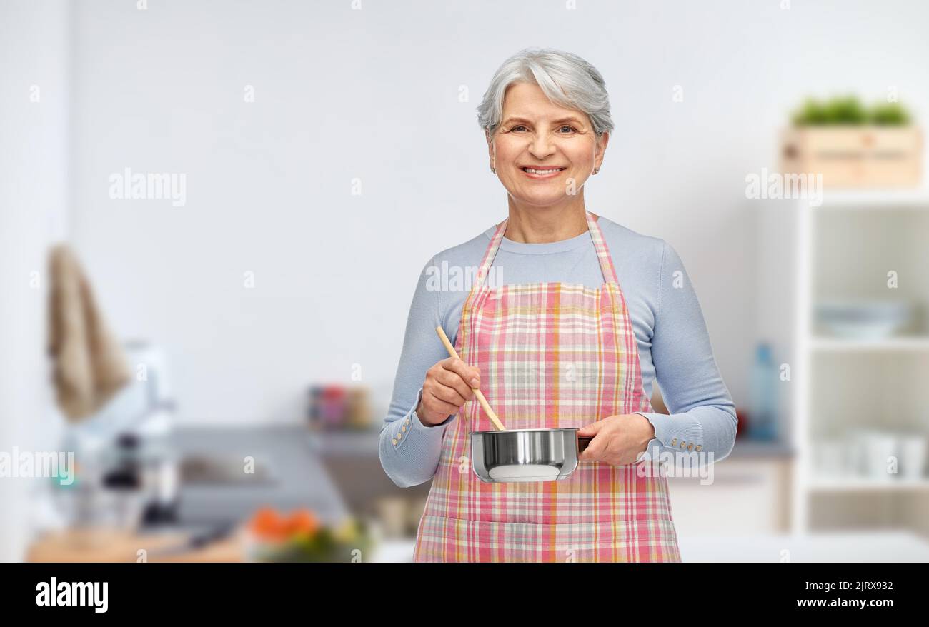 old woman in kitchen apron with pot cooking food Stock Photo - Alamy
