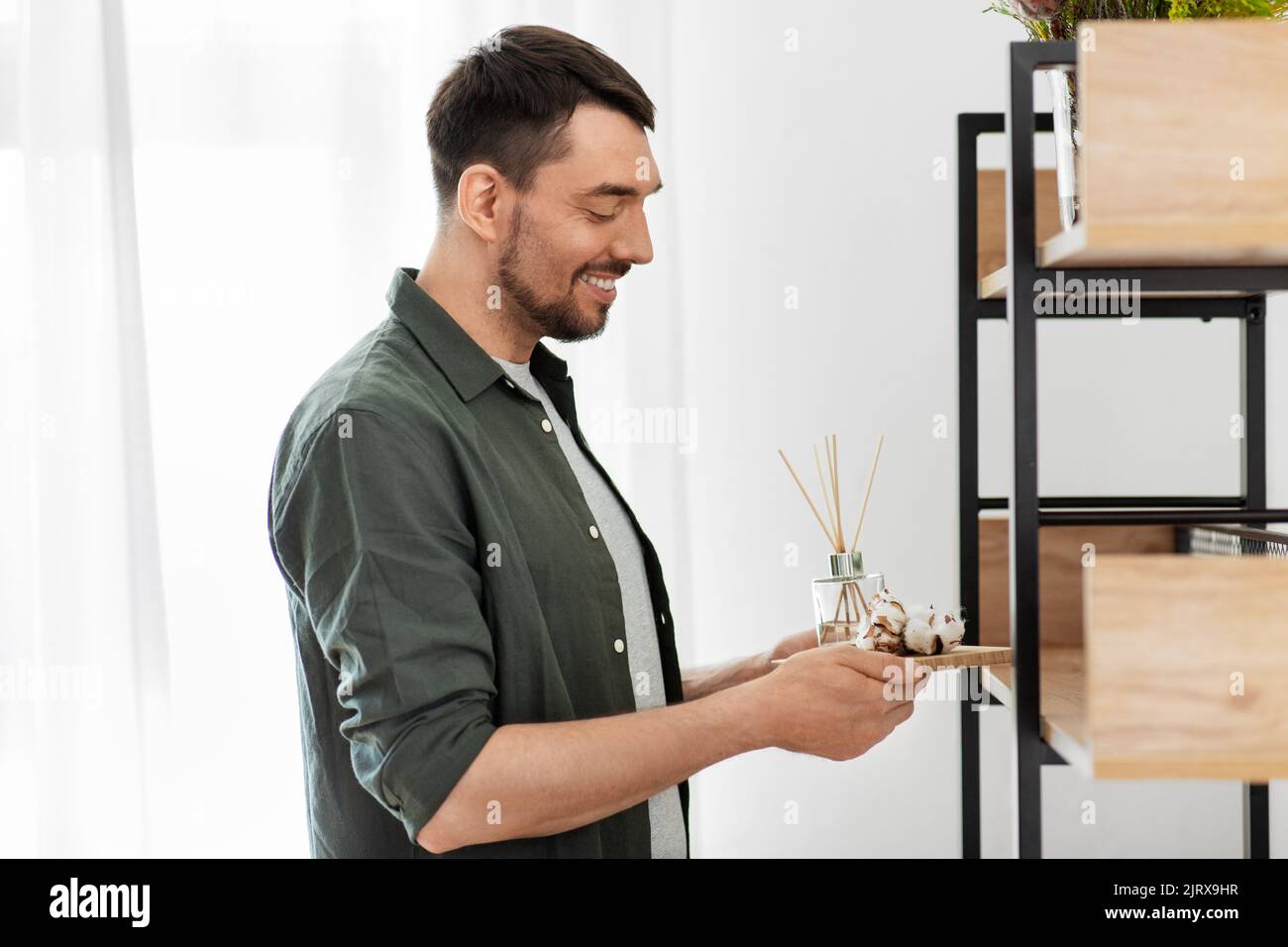 man placing aroma reed diffuser to shelf home Stock Photo - Alamy