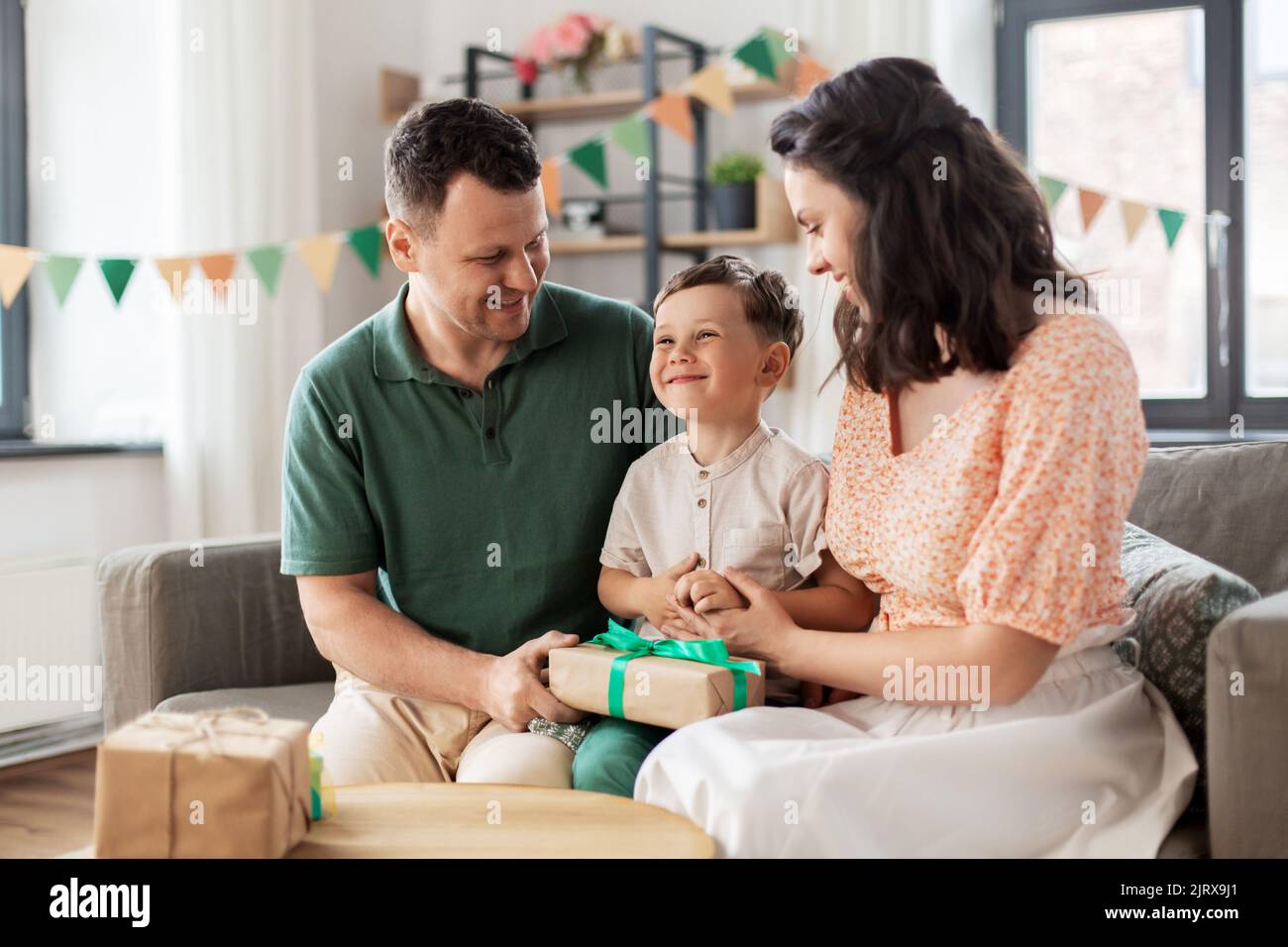 parents giving birthday present to little son Stock Photo - Alamy