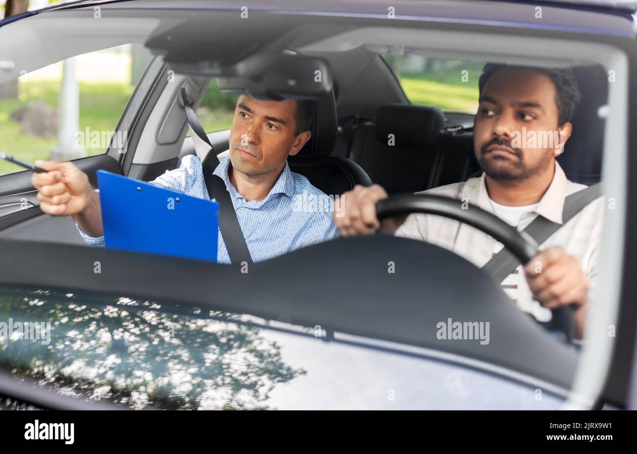 car driving school instructor and young driver Stock Photo - Alamy