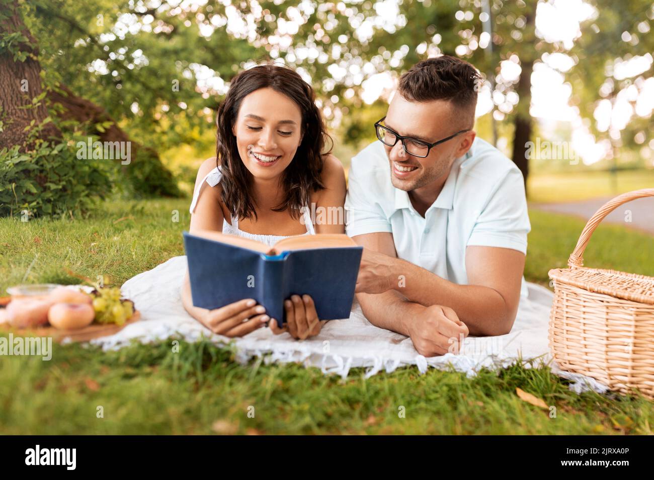 happy couple reading book on picnic at summer park Stock Photo - Alamy