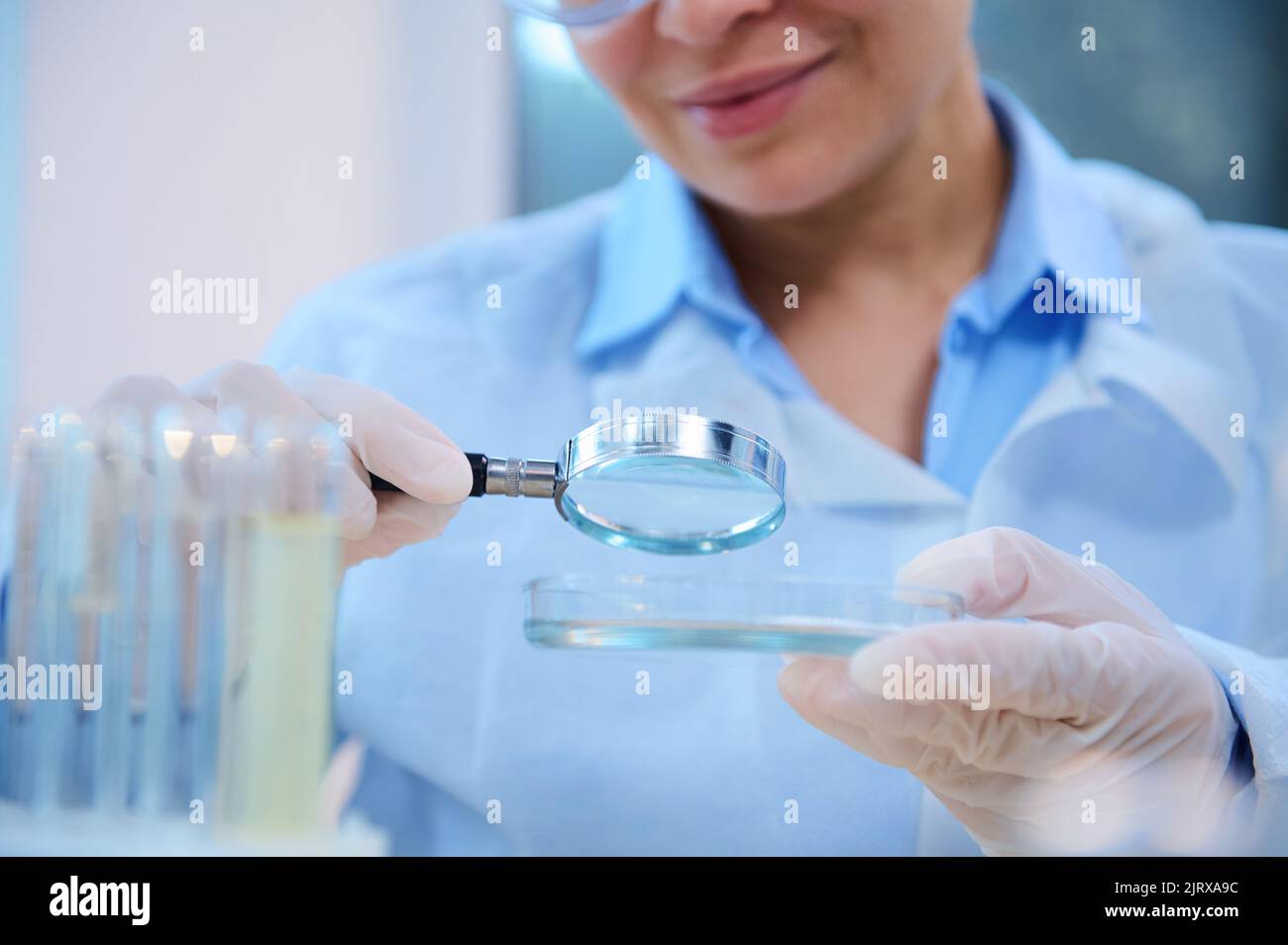 Loupe with magnifying glass in the hand of a female scientist, medical ...