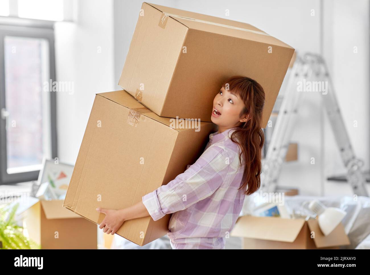 woman holding heavy boxes and moving to new home Stock Photo - Alamy