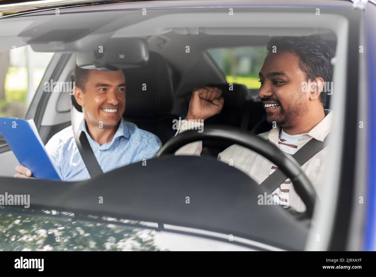 smiling car driving school instructor and driver Stock Photo - Alamy