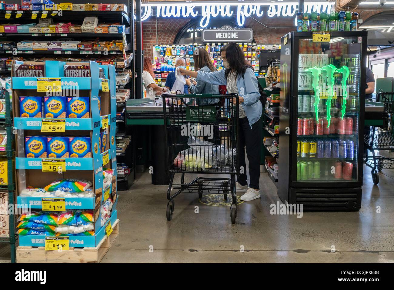 Consumers wait at a check-out line after shopping in a supermarket in ...