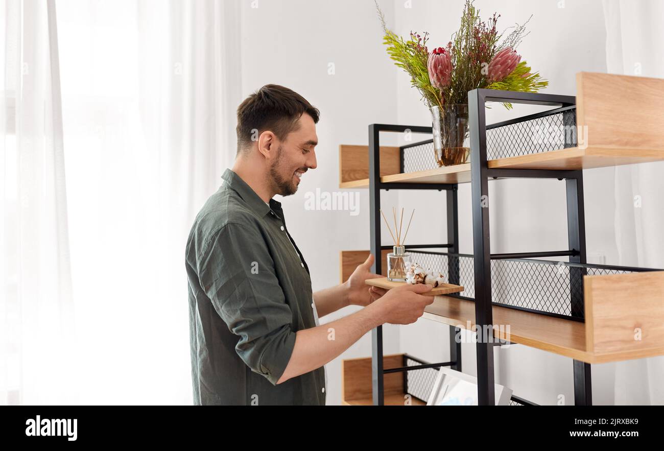 man placing aroma reed diffuser to shelf home Stock Photo - Alamy