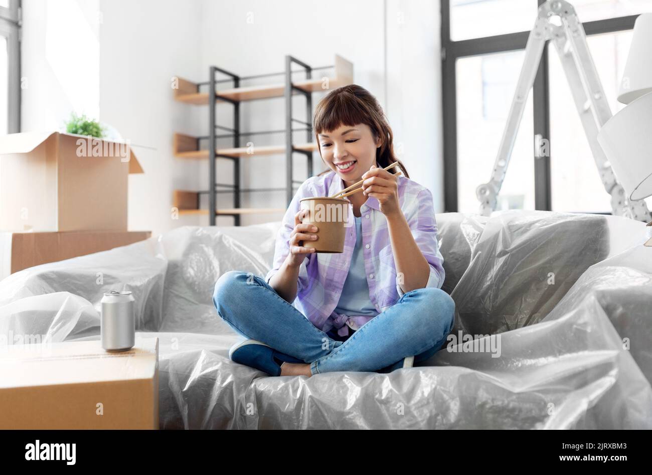 happy woman moving to new home and eating wok Stock Photo - Alamy