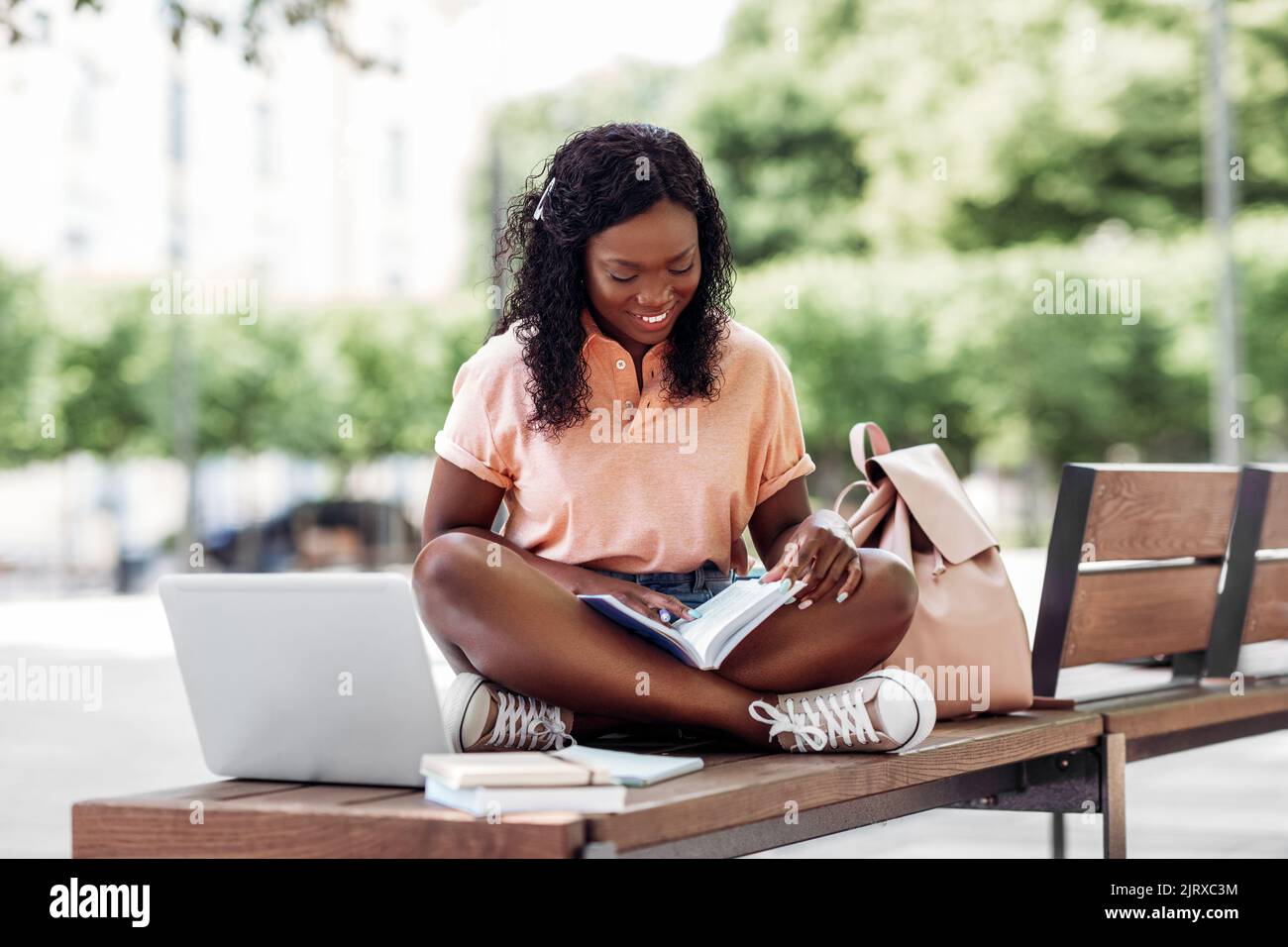 african student girl reading book in city Stock Photo - Alamy