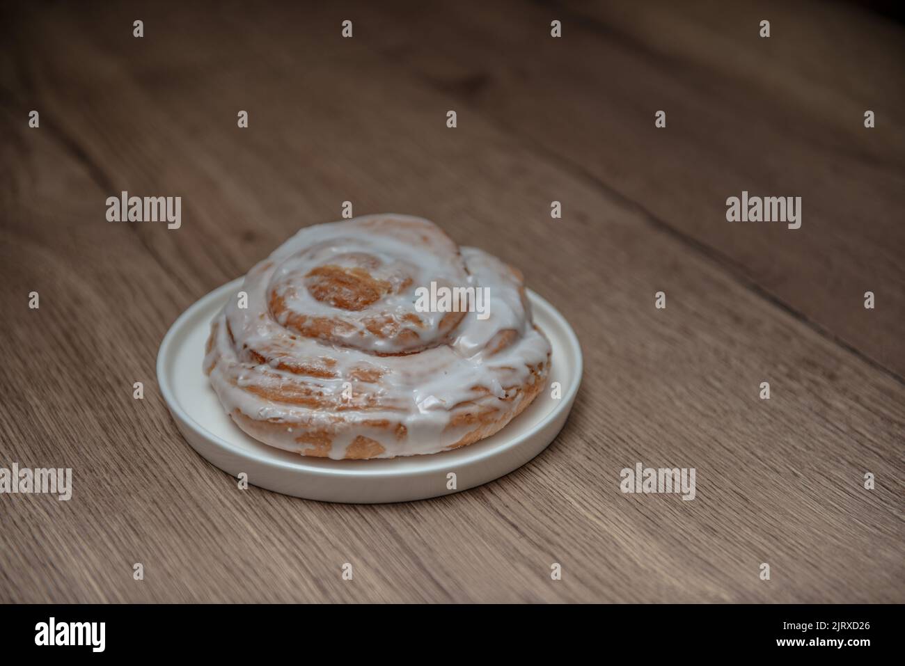 Snail buns on a white plate and wooden background. Cinnamon rolls ...