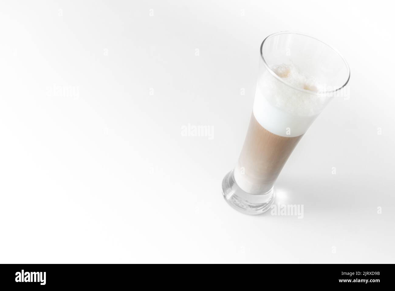 multi-layer coffee in a transparent, glass glass at an angle on a white ...