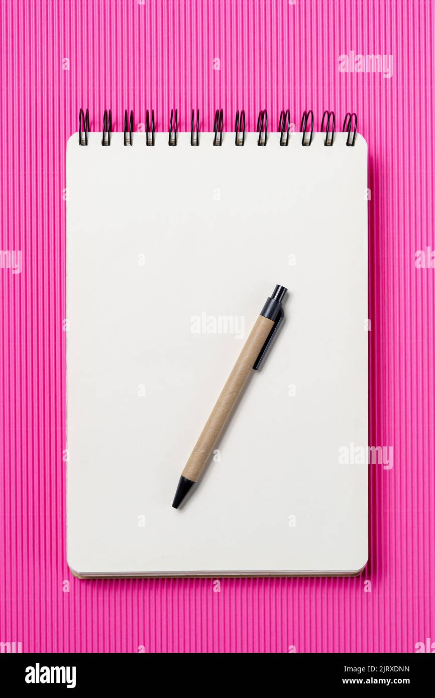 School notebook on a paper pink background, spiral notepad and craft ...