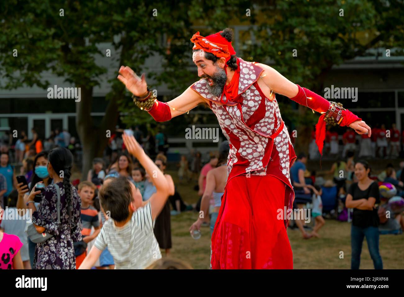 Stilt performer gives high five to young boy, Trout Lake, John Hendry ...