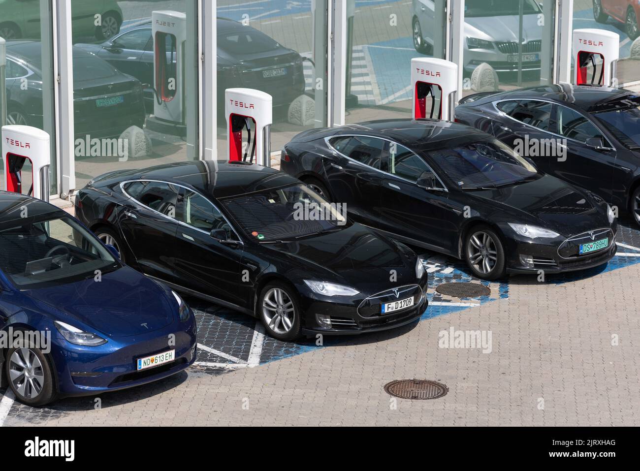 Vehicles seen at a Tesla charging station in Bratislava. EVs are ...