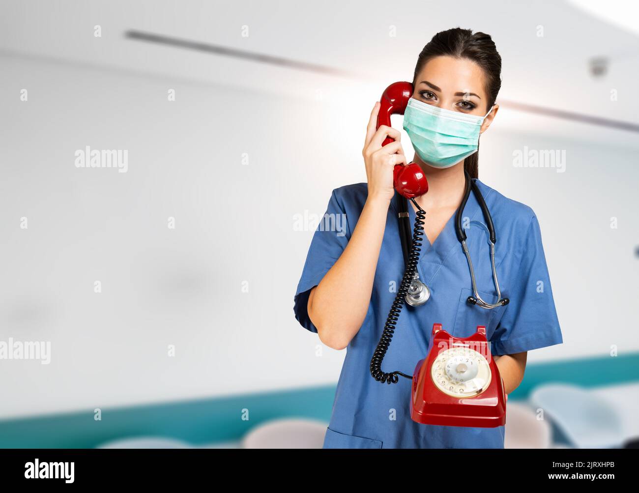 Nurse making a phone call, with a vintage telephone covid and ...