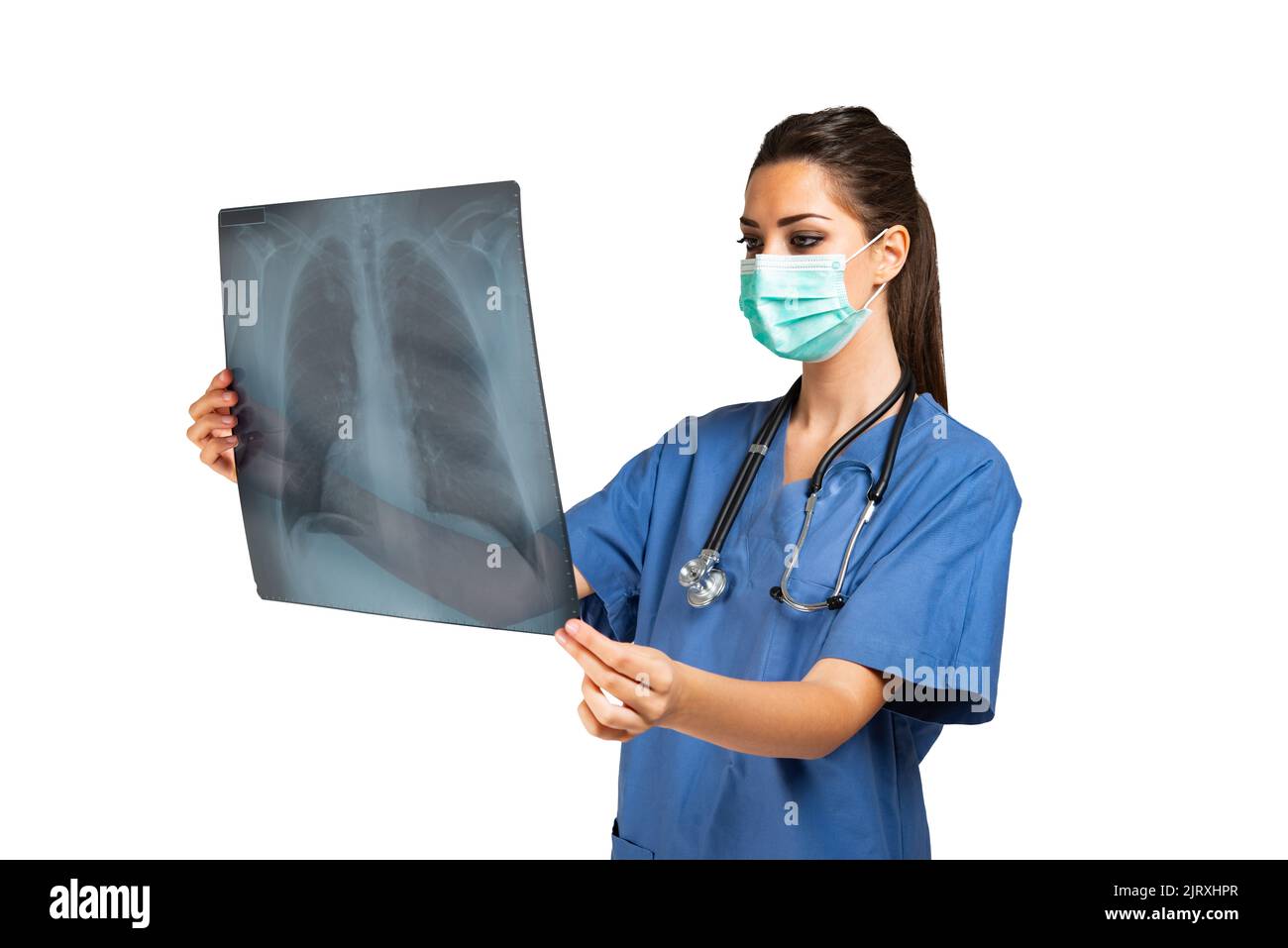 Young masked nurse looking at a radiography, covid and coronavirus ...