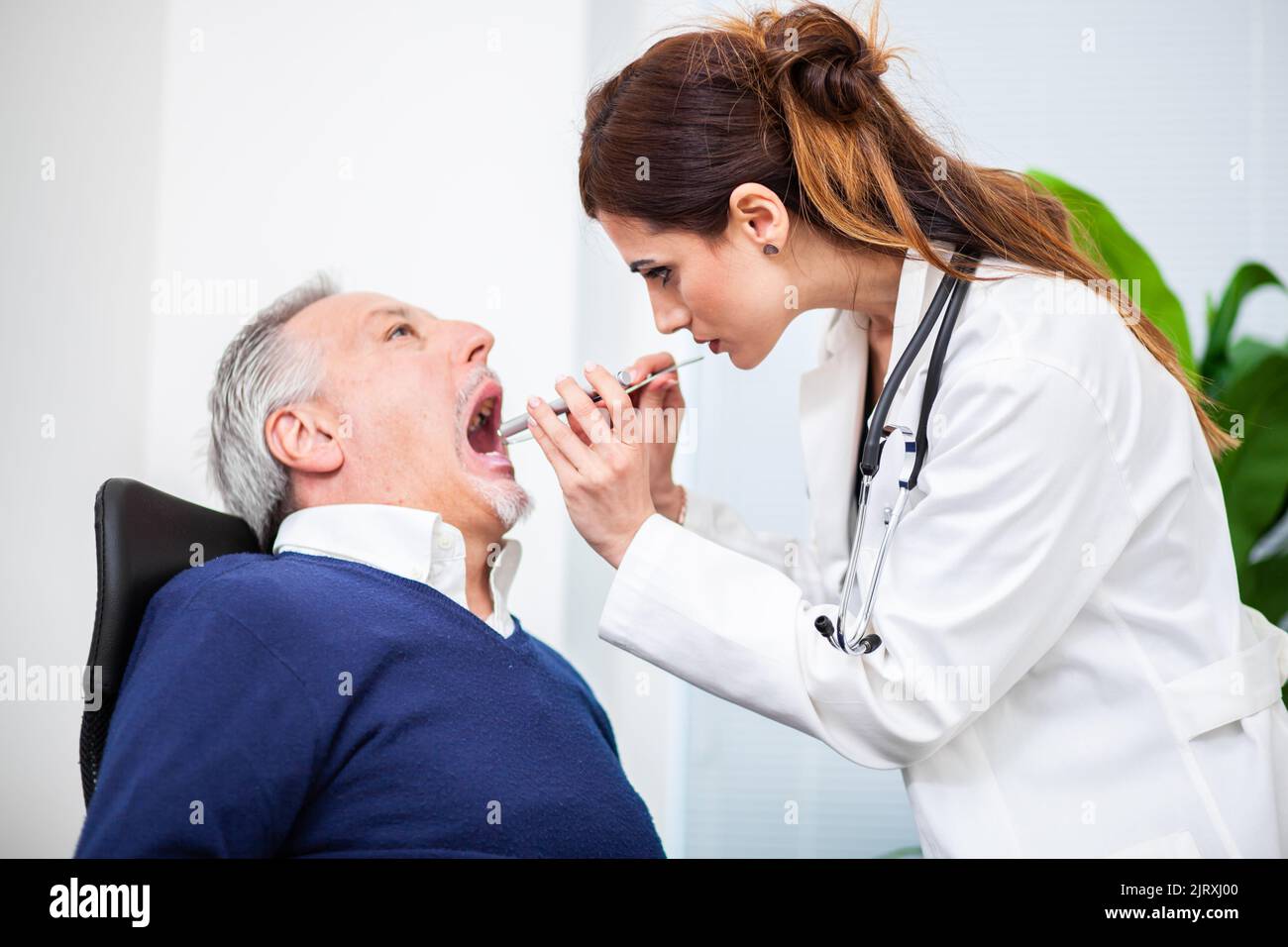 Doctor examining a patient in her office Stock Photo - Alamy