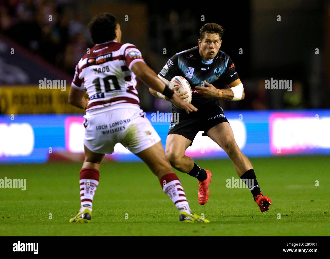 St Helens' Louie McCarthy-Scarsbrook (right) in action against Wigan ...