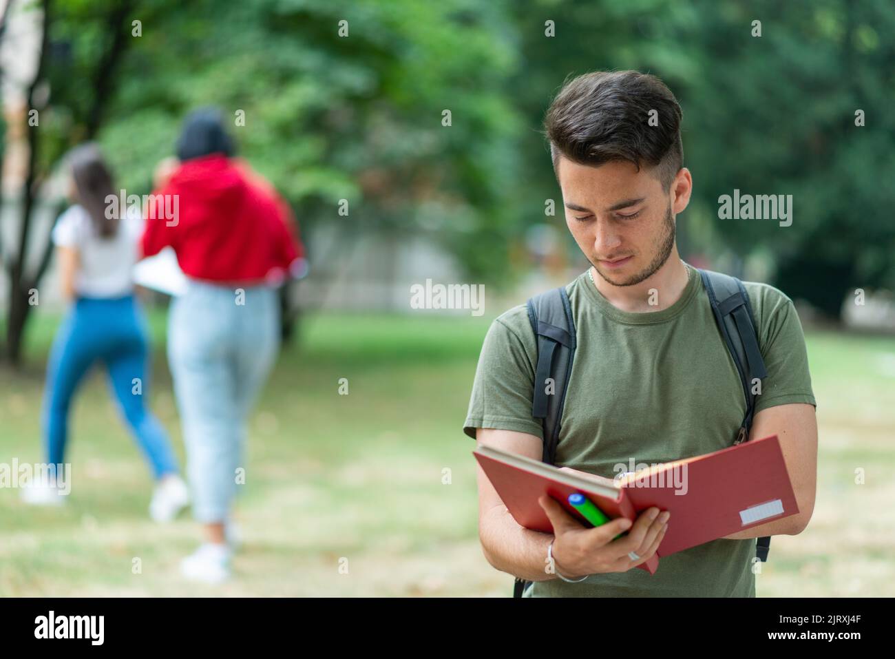 Outdoor portrait of a student reading a book Stock Photo - Alamy