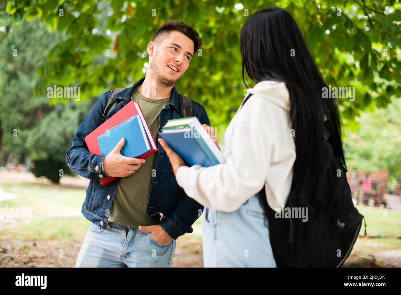 Couple of students talking together in a park outdoor Stock Photo - Alamy