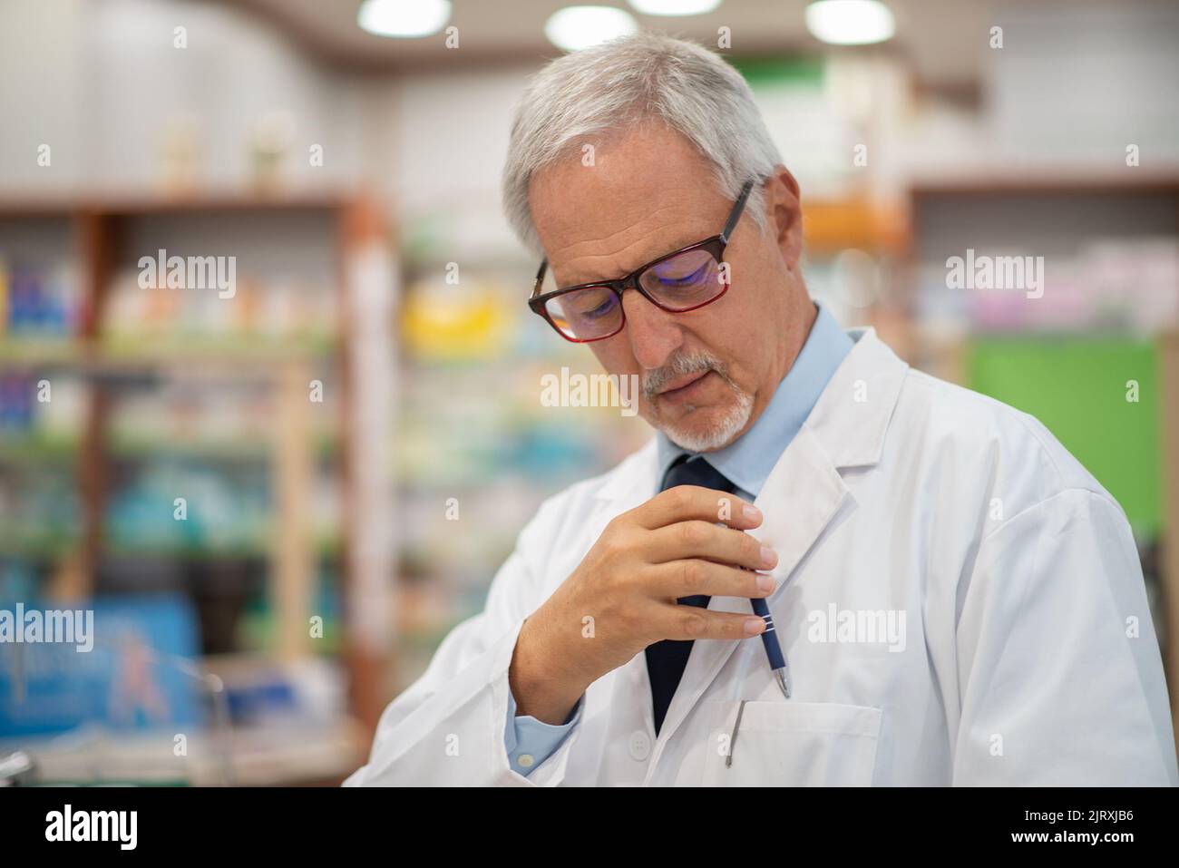 Senior pharmacist taking a pen from his pocket Stock Photo - Alamy