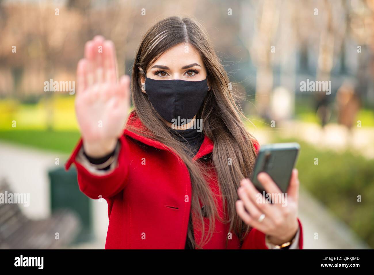Masked woman showing the stop sign, coronavirus pandemic social ...