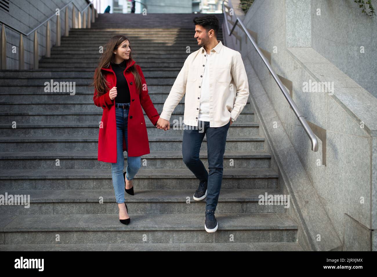 Happy couple walking down a staircase together Stock Photo - Alamy