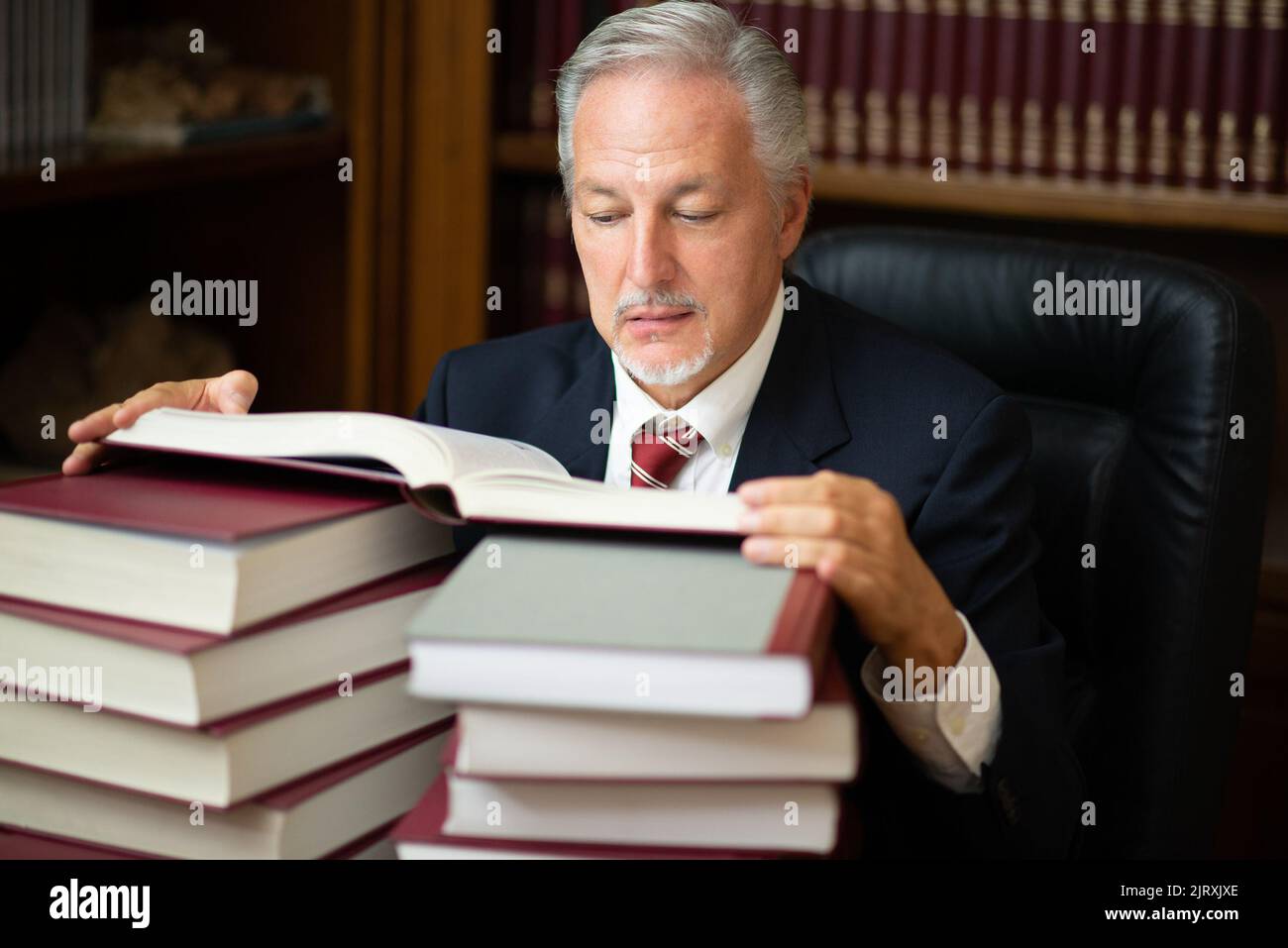 Business man reading a lot of books in his studio Stock Photo - Alamy