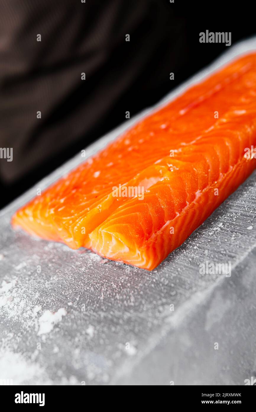 Fresh raw salmon fillet with seasonings and herbs on the block of ice ...
