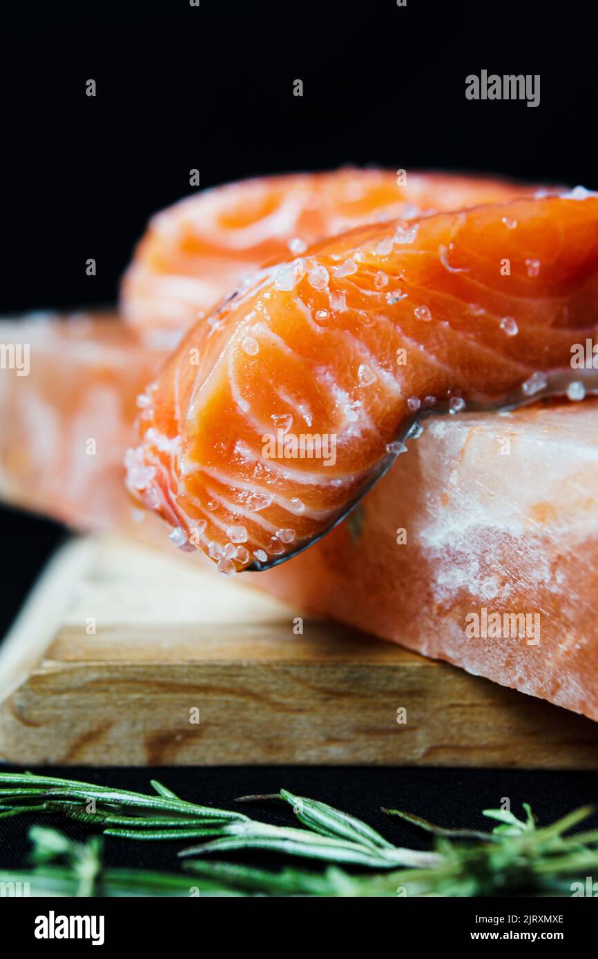 Fresh raw salmon fillet with seasonings and herbs on the block of ...