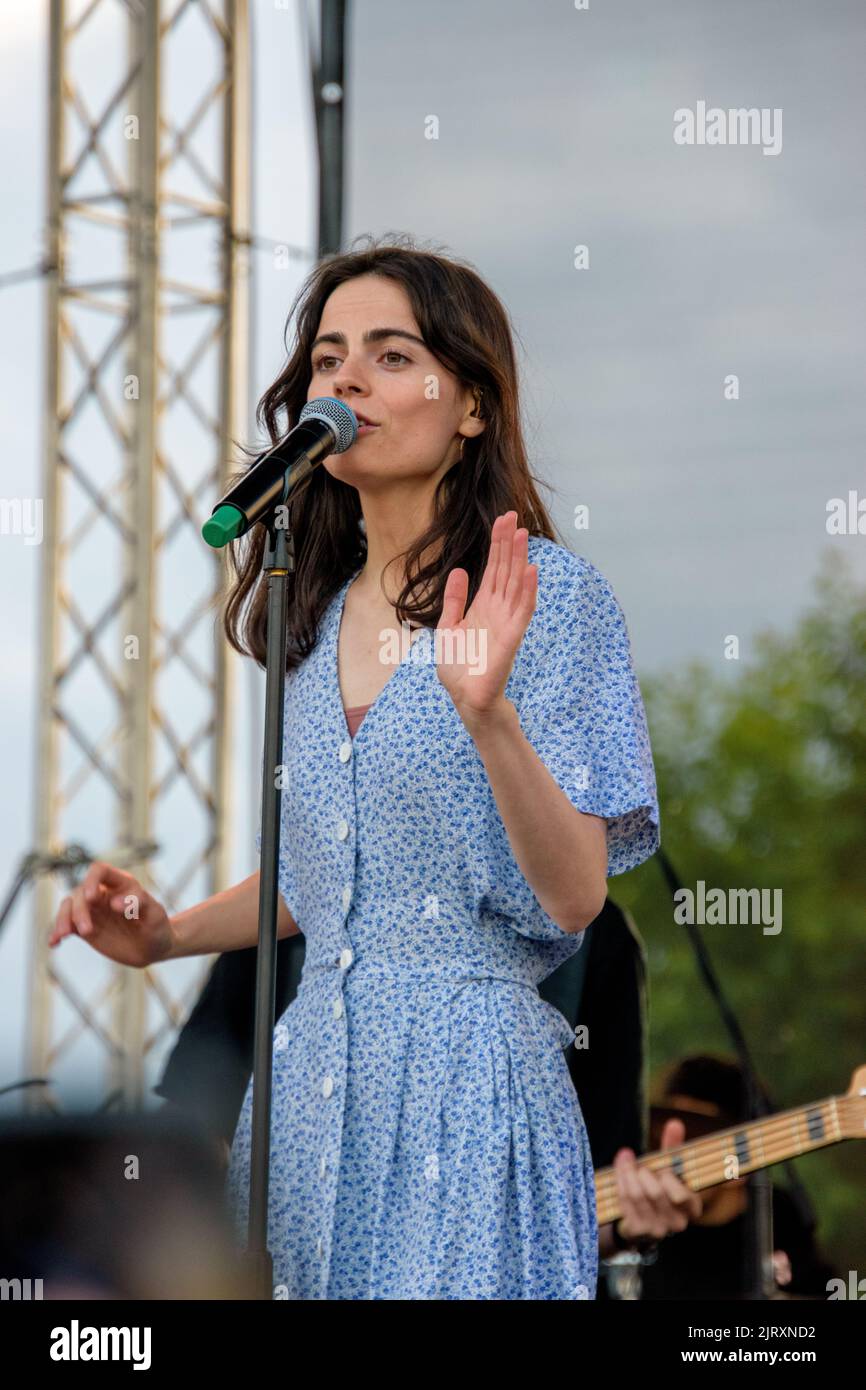 a closeup of Valeria Stoica singing at her live concert with a guitar ...