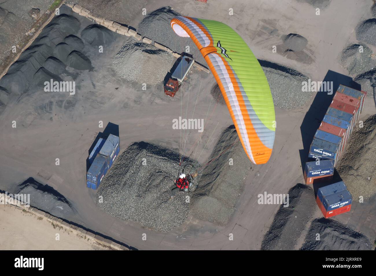 paragliding pilot flying in smooth air on colorfum paraglider wings in ...