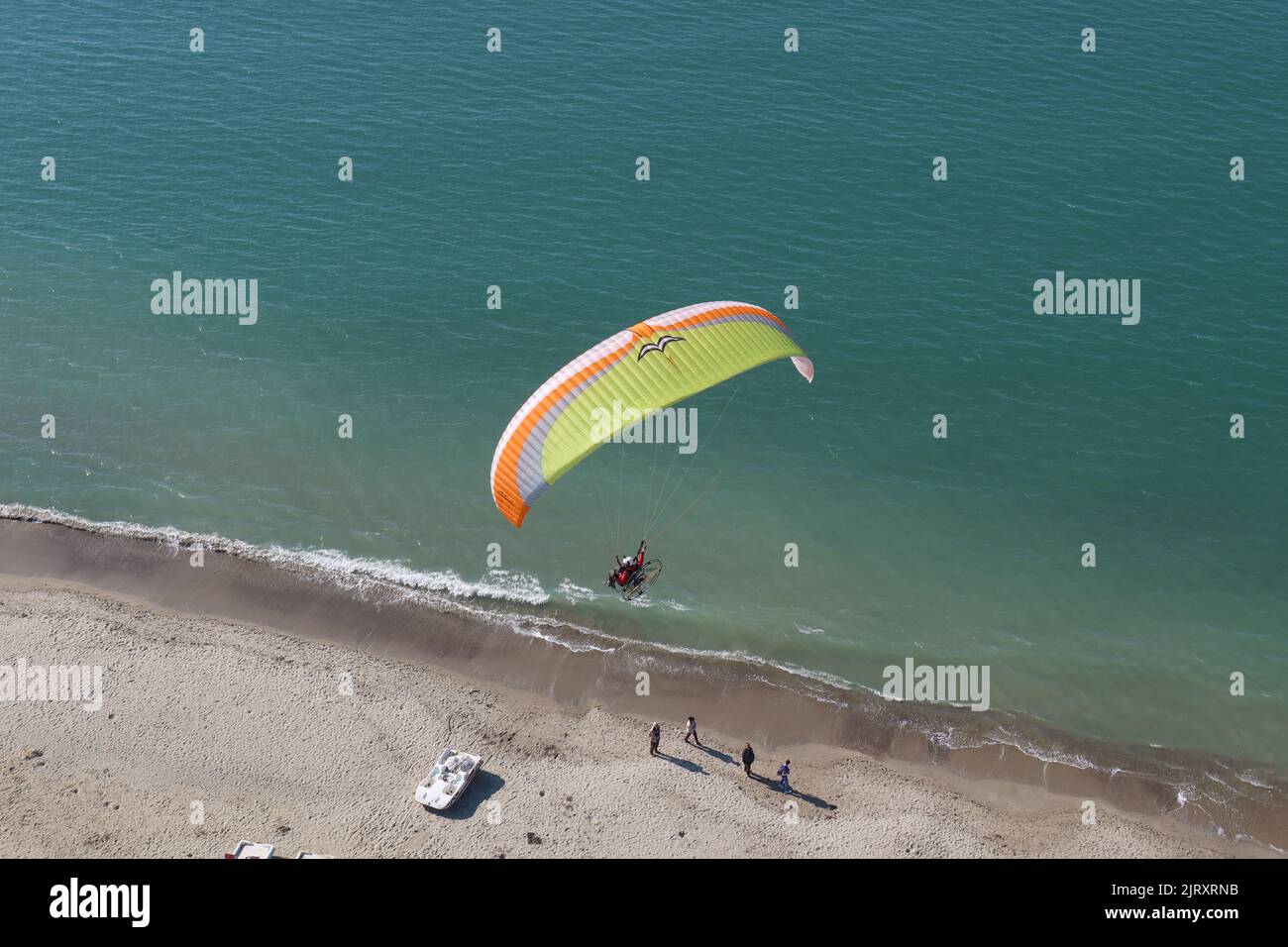 paragliding pilot flying in smooth air on colorfum paraglider wings in ...