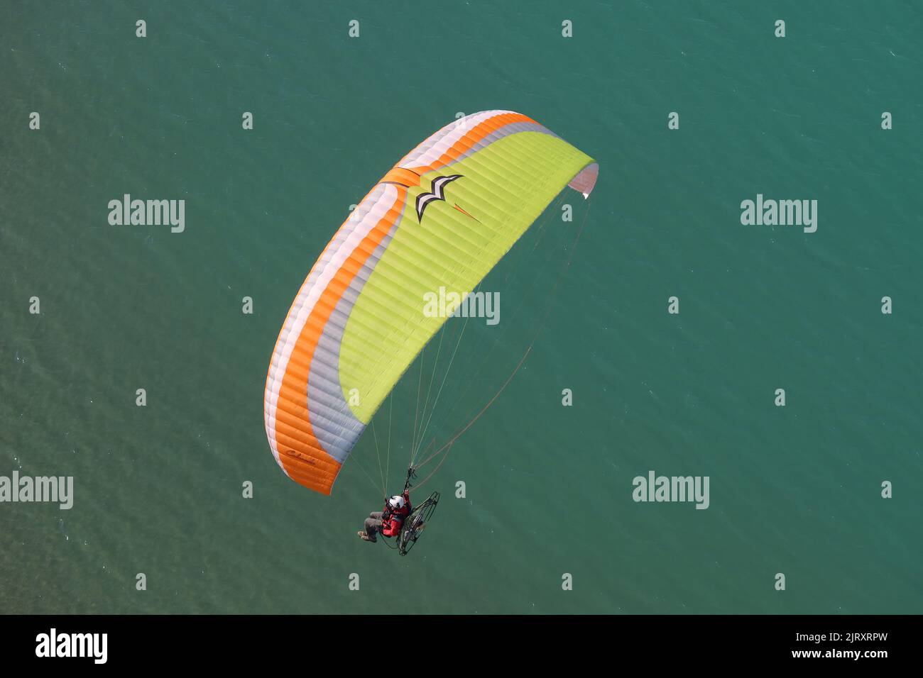 paragliding pilot flying in smooth air on colorfum paraglider wings in ...