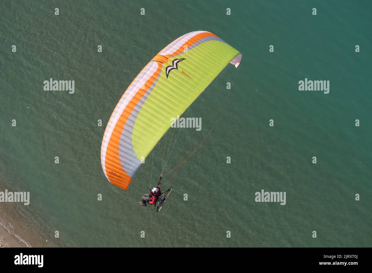 paragliding pilot flying in smooth air on colorfum paraglider wings in ...