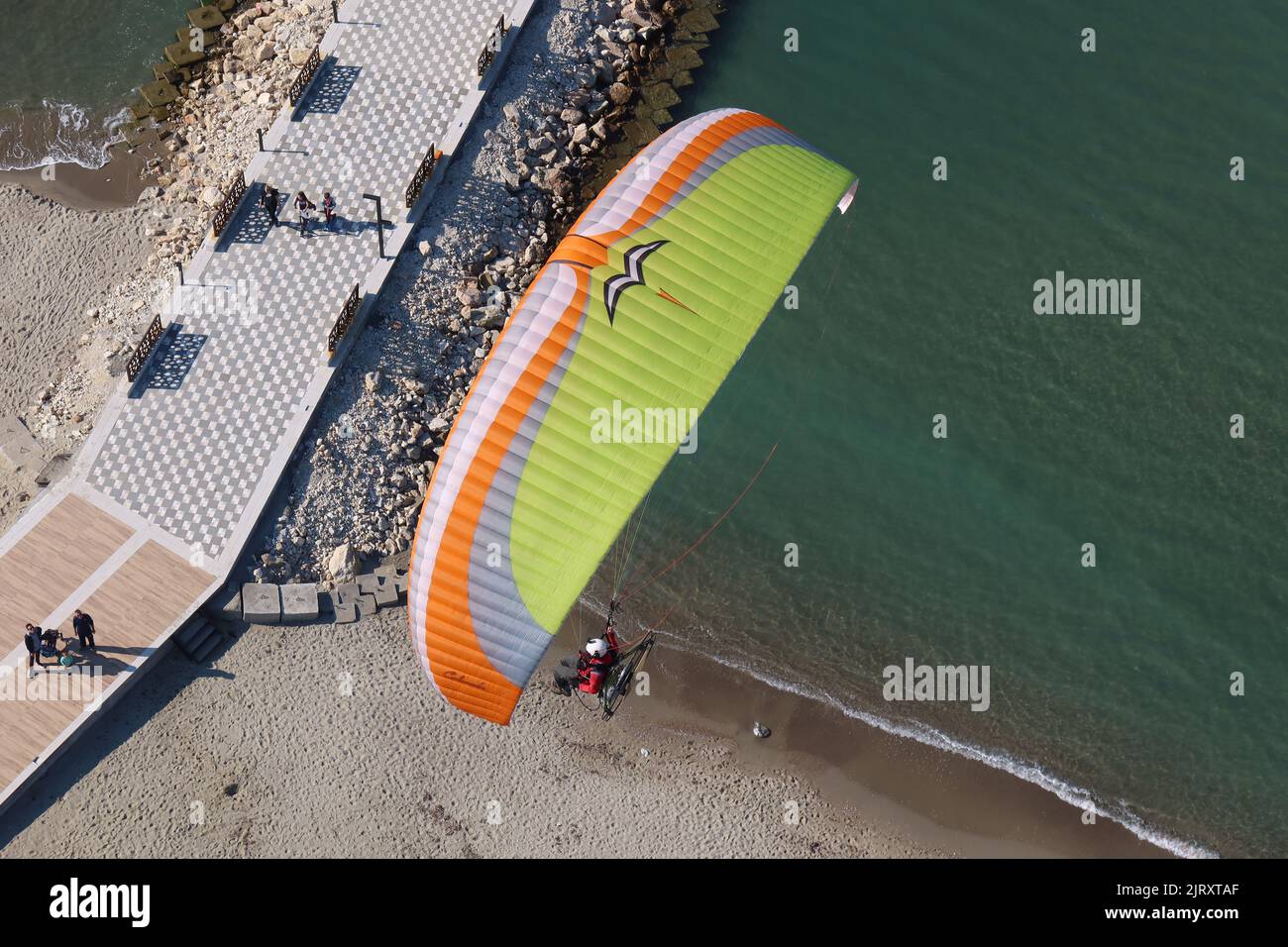paragliding pilot flying in smooth air on colorfum paraglider wings in ...