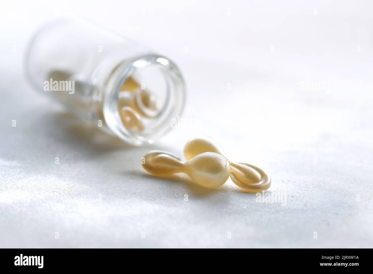 Serum capsules for healthy skin. Close-up on transparent bottle with ...