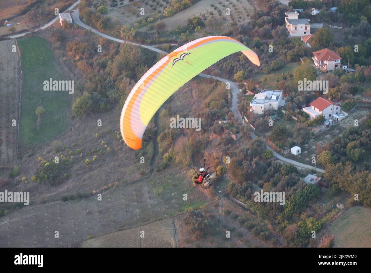 paragliding pilot flying in smooth air on colorfum paraglider wings in ...