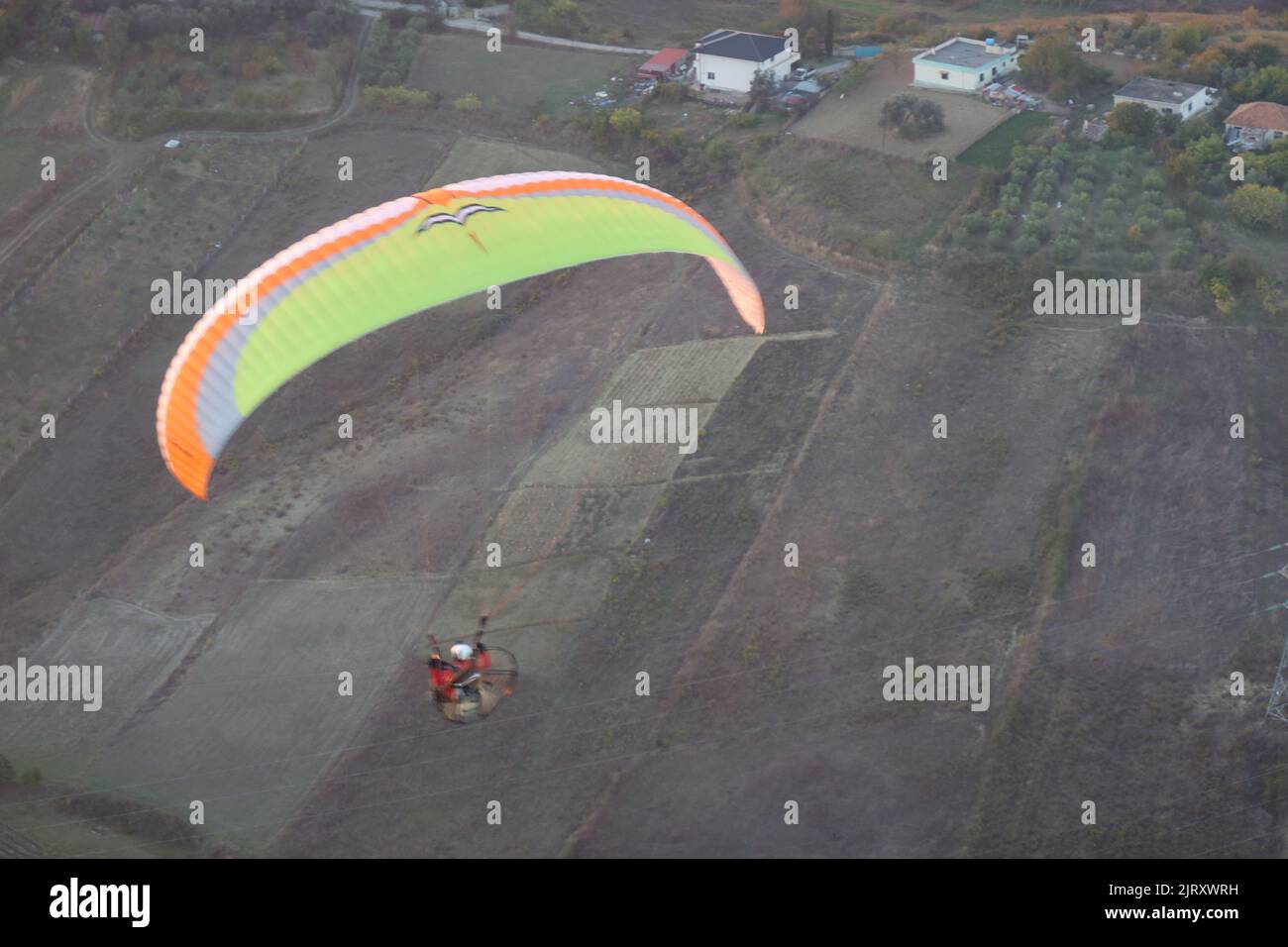 paragliding pilot flying in smooth air on colorfum paraglider wings in ...