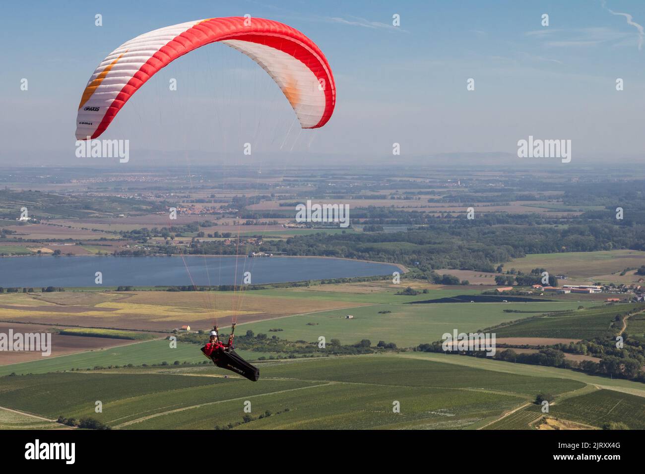 paragliding pilot flying in smooth air on colorfum paraglider wings in ...