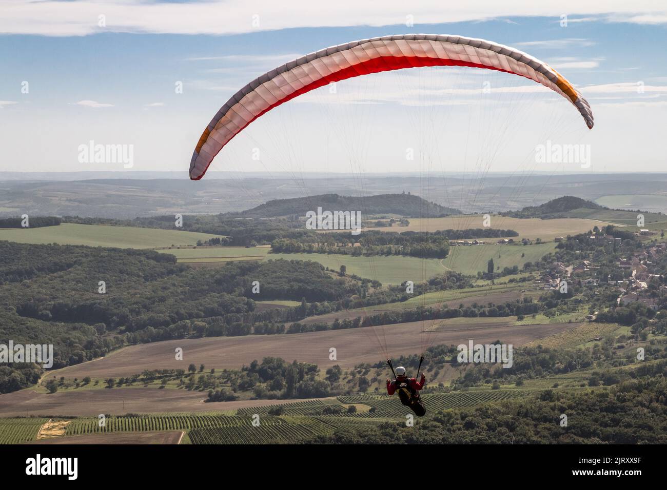 paragliding pilot flying in smooth air on colorfum paraglider wings in ...