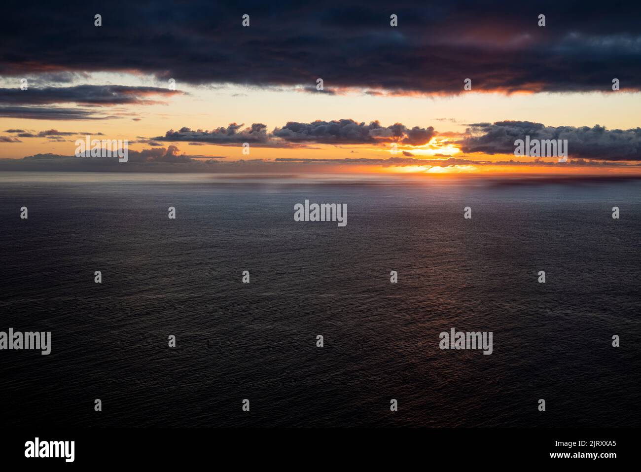 Picturesque seascape with illuminated clouds at sunset over the ...