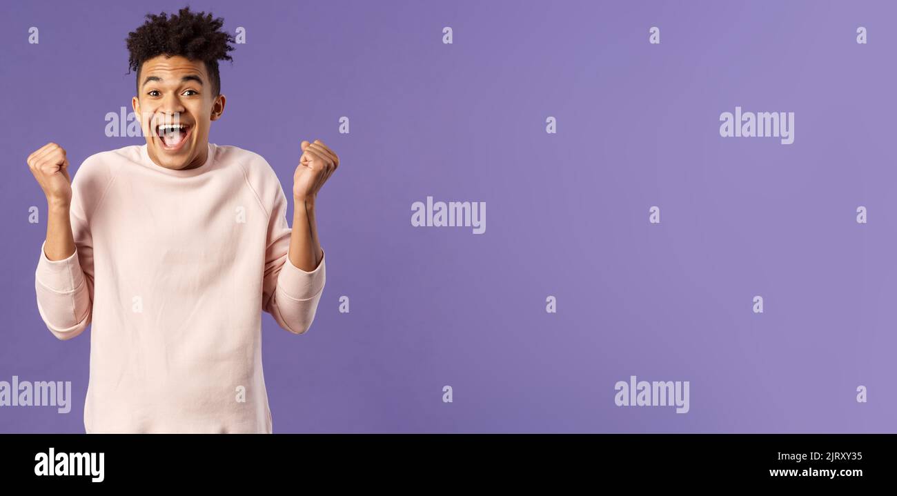 Portrait of happy, cheerful triumphing young hipster guy with dreads ...