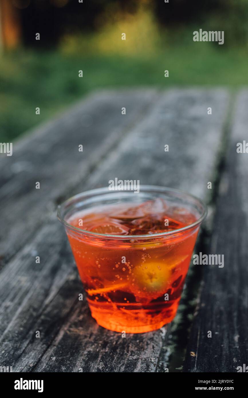 Aperol Spritz aperitif cocktail in plastic cup on picnic table Stock ...