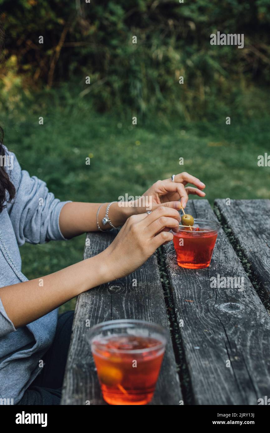 Woman with Aperol Spritz cocktail with green olive garnish Stock Photo ...