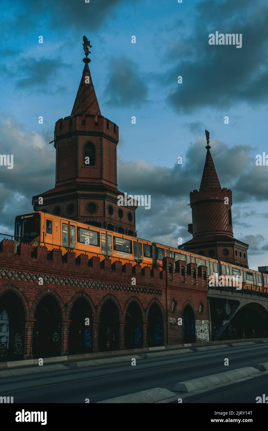 A picture of a metro train on a bridge in front of an old building in ...
