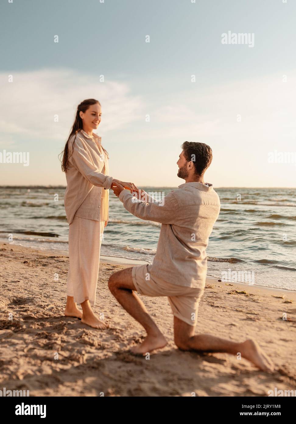 man with ring making proposal to woman on beach Stock Photo - Alamy