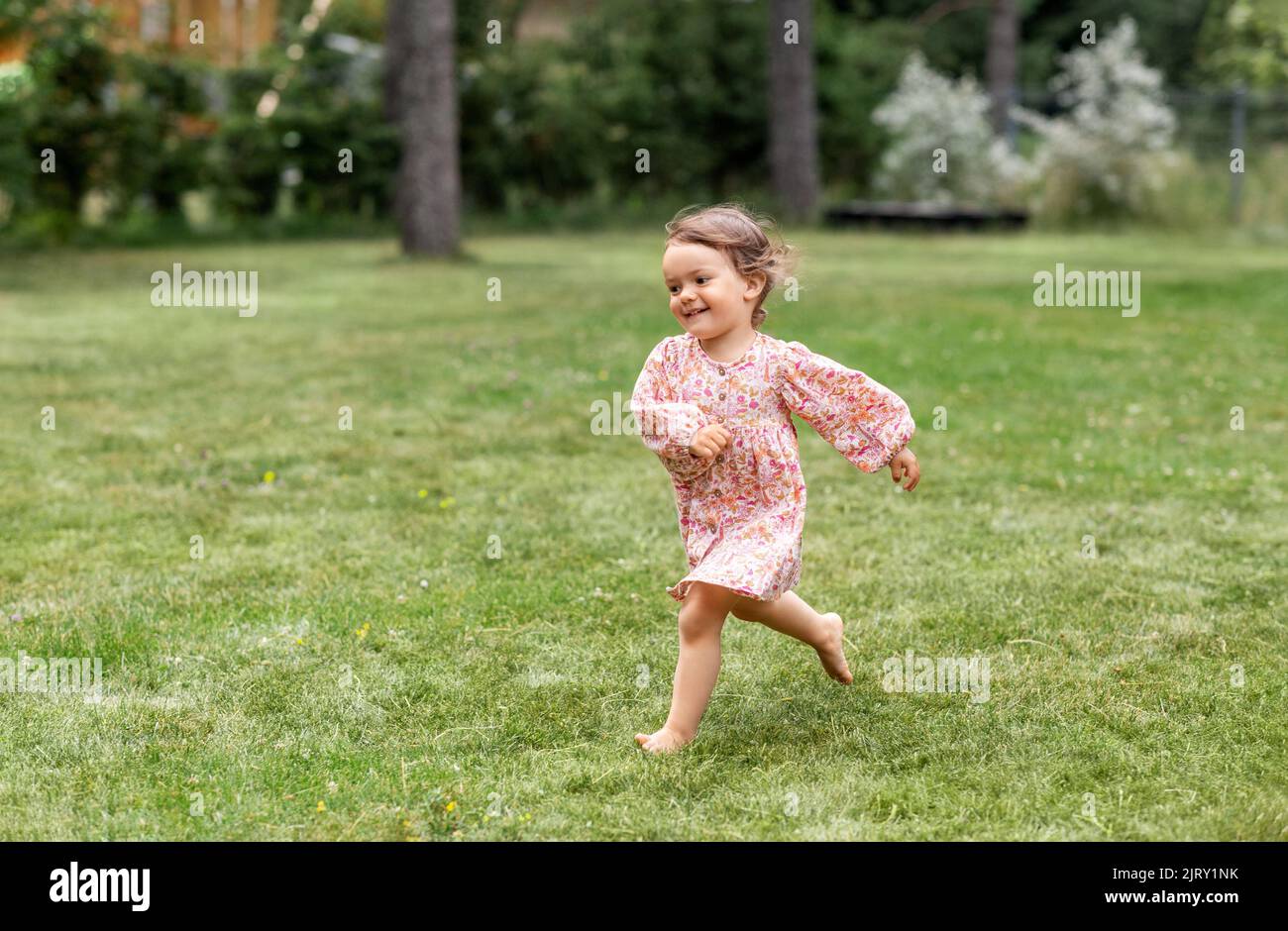 happy little baby girl running across summer field Stock Photo - Alamy