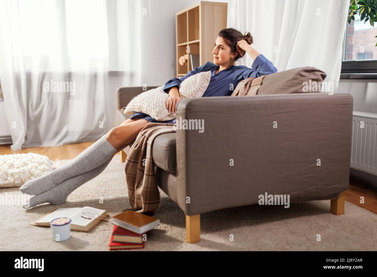 woman with pillow and books on floor at home Stock Photo - Alamy