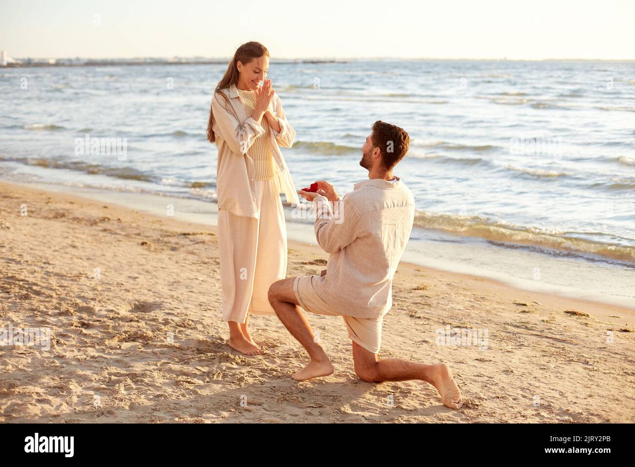 man with ring making proposal to woman on beach Stock Photo - Alamy